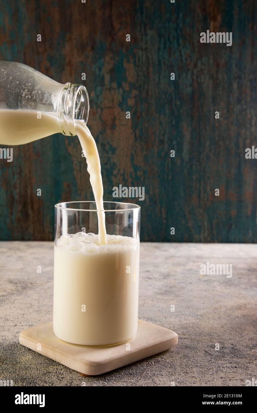 Milk being poured into a glass from a bottle Stock Photo - Alamy