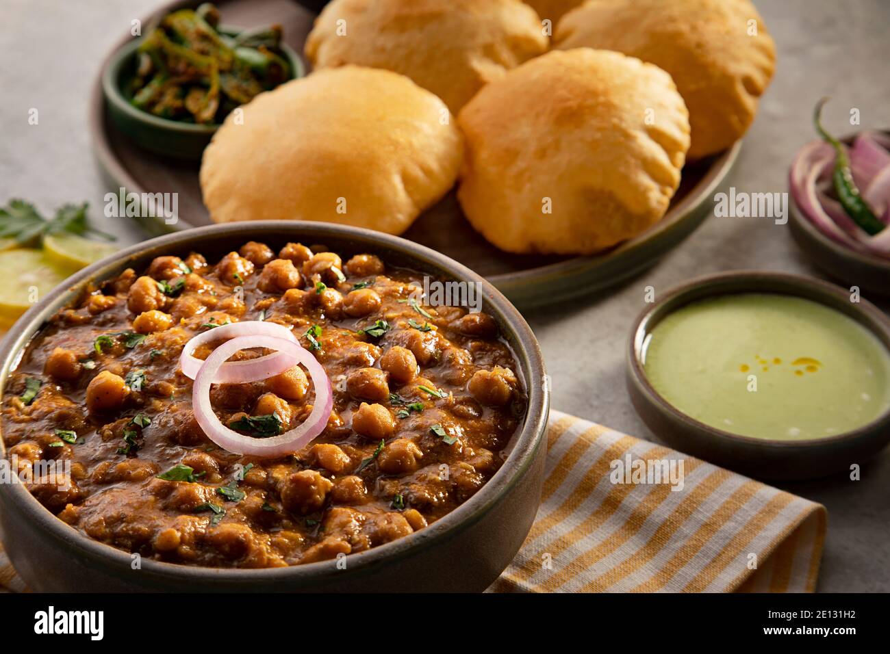 CHOLE CURRY POURED INTO A KADHAI WITH PURIS AND CHUTNEY BESIDES Stock ...