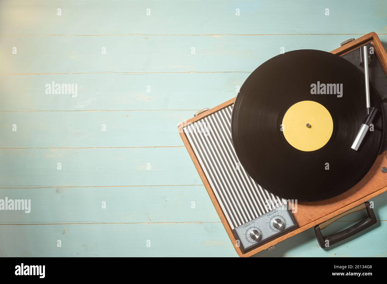 Vintage gramophone with a vinyl record on green wooden table, top view ...