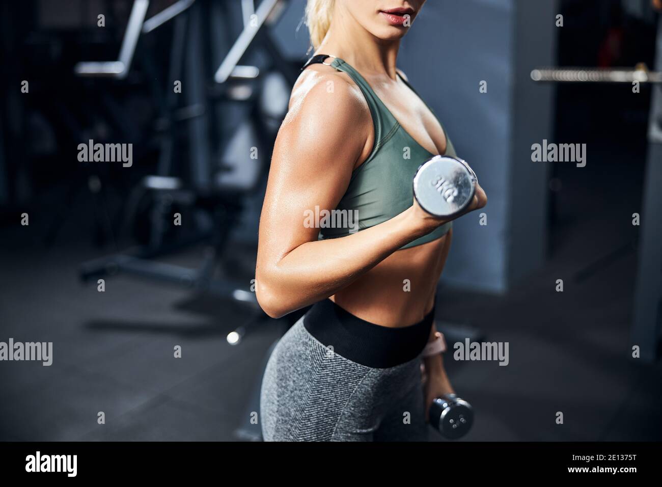 Female pretty sportsperson is doing dumbbell curls Stock Photo - Alamy