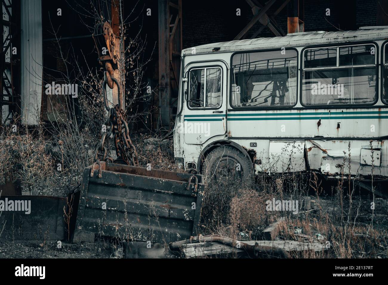 Old retro rusty broken abandoned bus in dark industrial post ...