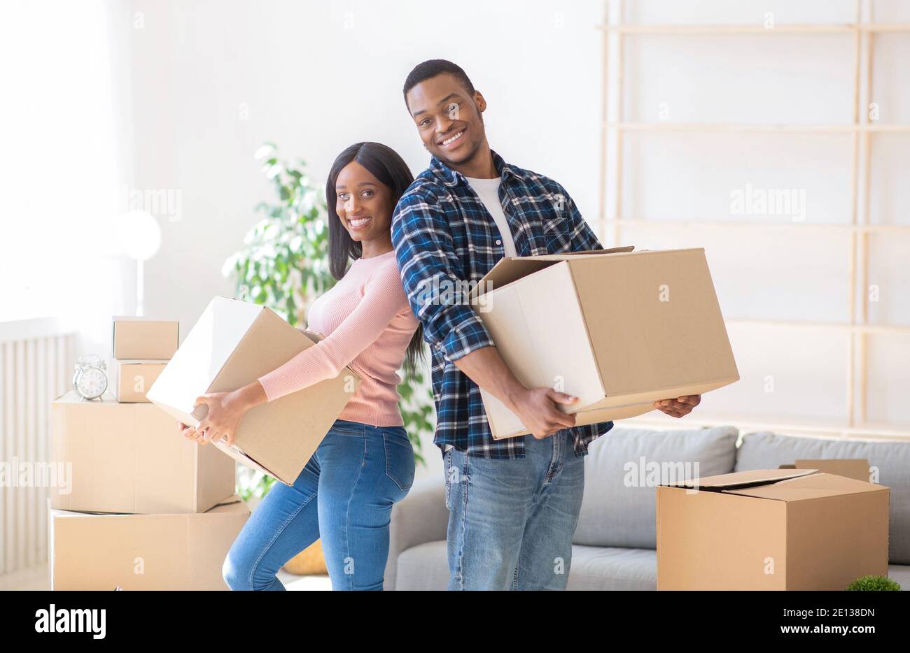 Young black homeowners with carton boxes feeling happy in their new ...