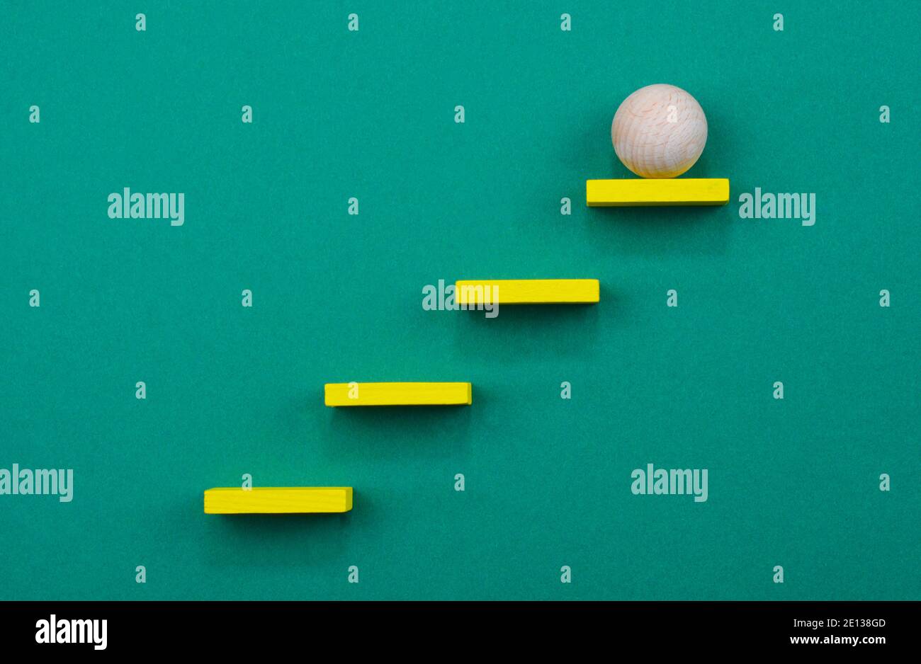 Leadership ball climbing the steps to the top Stock Photo - Alamy