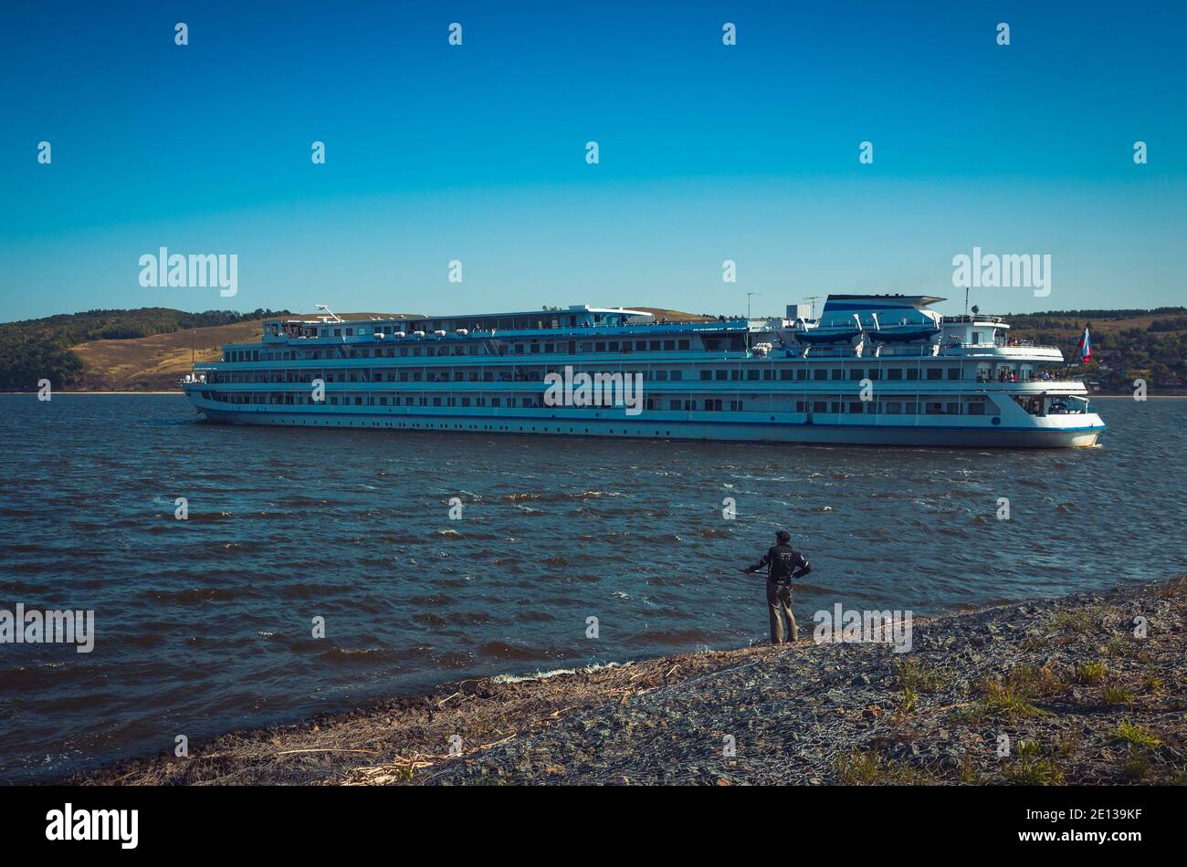 Cruise ship and a lonely fisherman on the shore of Sviyazhsk, Tatarstan ...