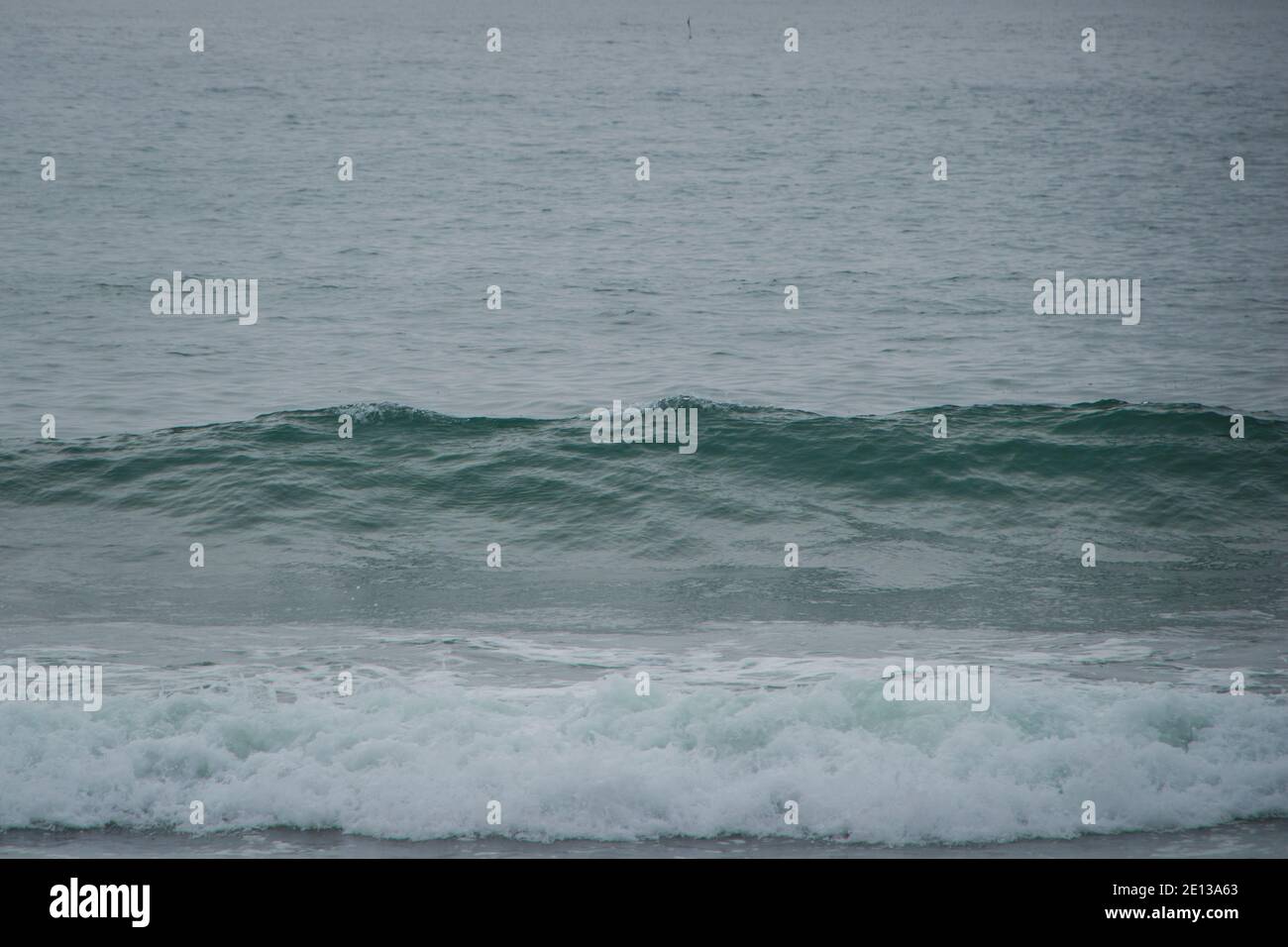 Minimalist image of a smooth wave coming ashore on a foggy day, with a ...
