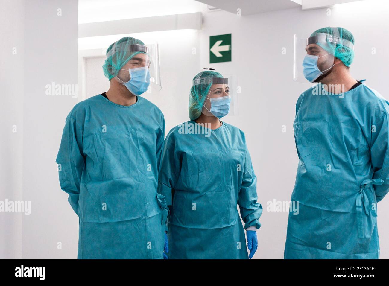 Doctors and nurse in hazmat suit talking in hospital corridor - Focus ...