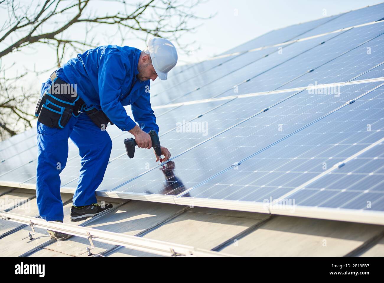 Male engineer in blue suit and protective helmet installing stand-alone ...
