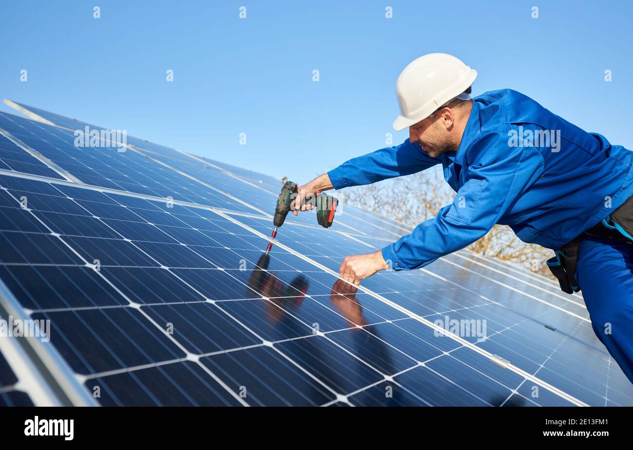 Male engineer in blue suit and protective helmet installing stand-alone ...