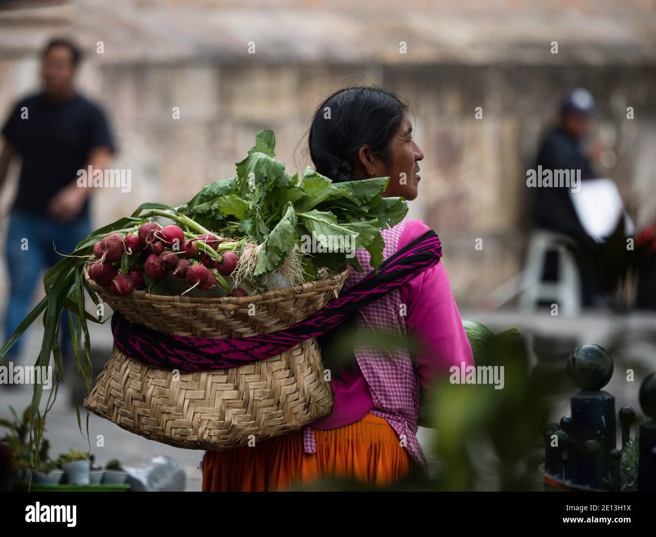 Indigenous woman in traditional andean dress costume carrying basket ...