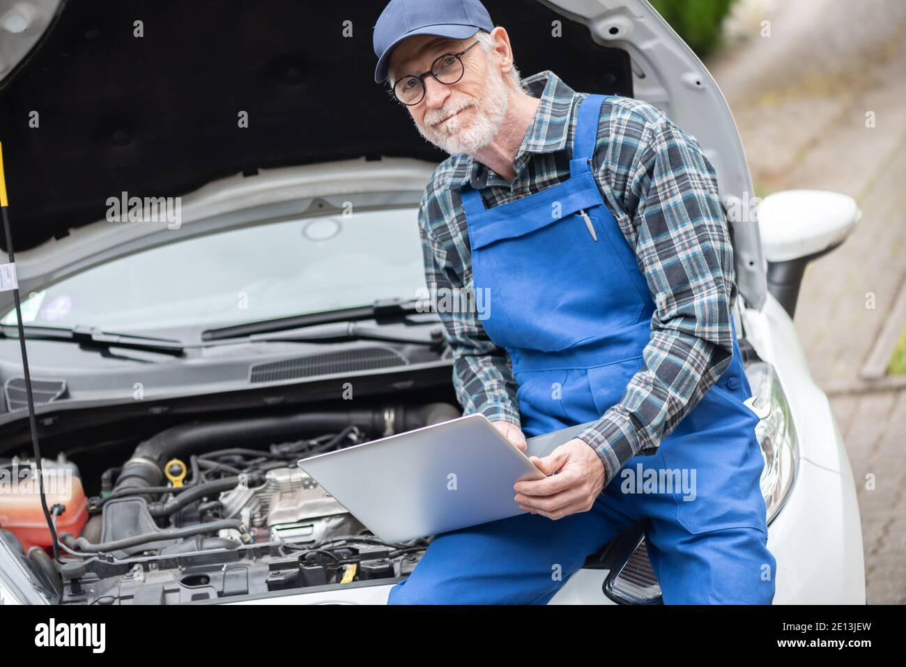 Car mechanic using laptop for checking car engine Stock Photo - Alamy