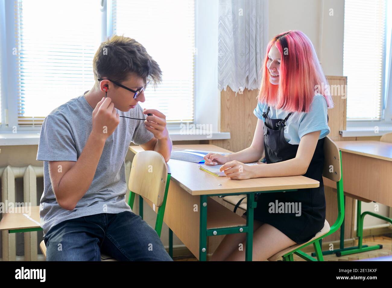 Students teenagers 16 years old in class, boy and girl talking, sitting ...