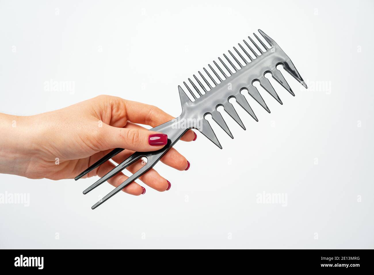 Female hand holding hair comb against white background Stock Photo - Alamy