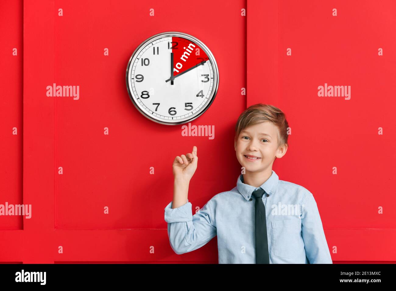 Little boy near clock with timer for 10 minutes on color background ...