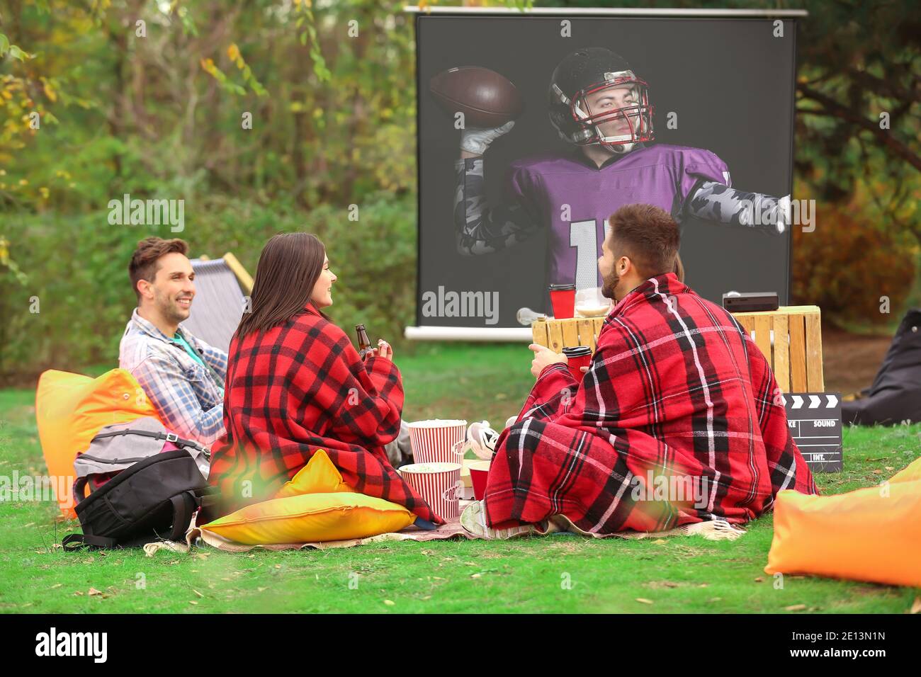 Friends watching American football in outdoor cinema Stock Photo - Alamy
