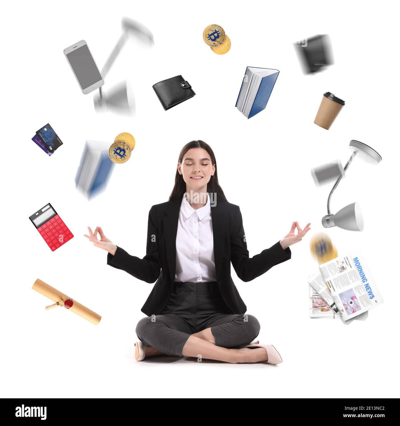 Different things flying around young businesswoman meditating on white background. Zen concept ...