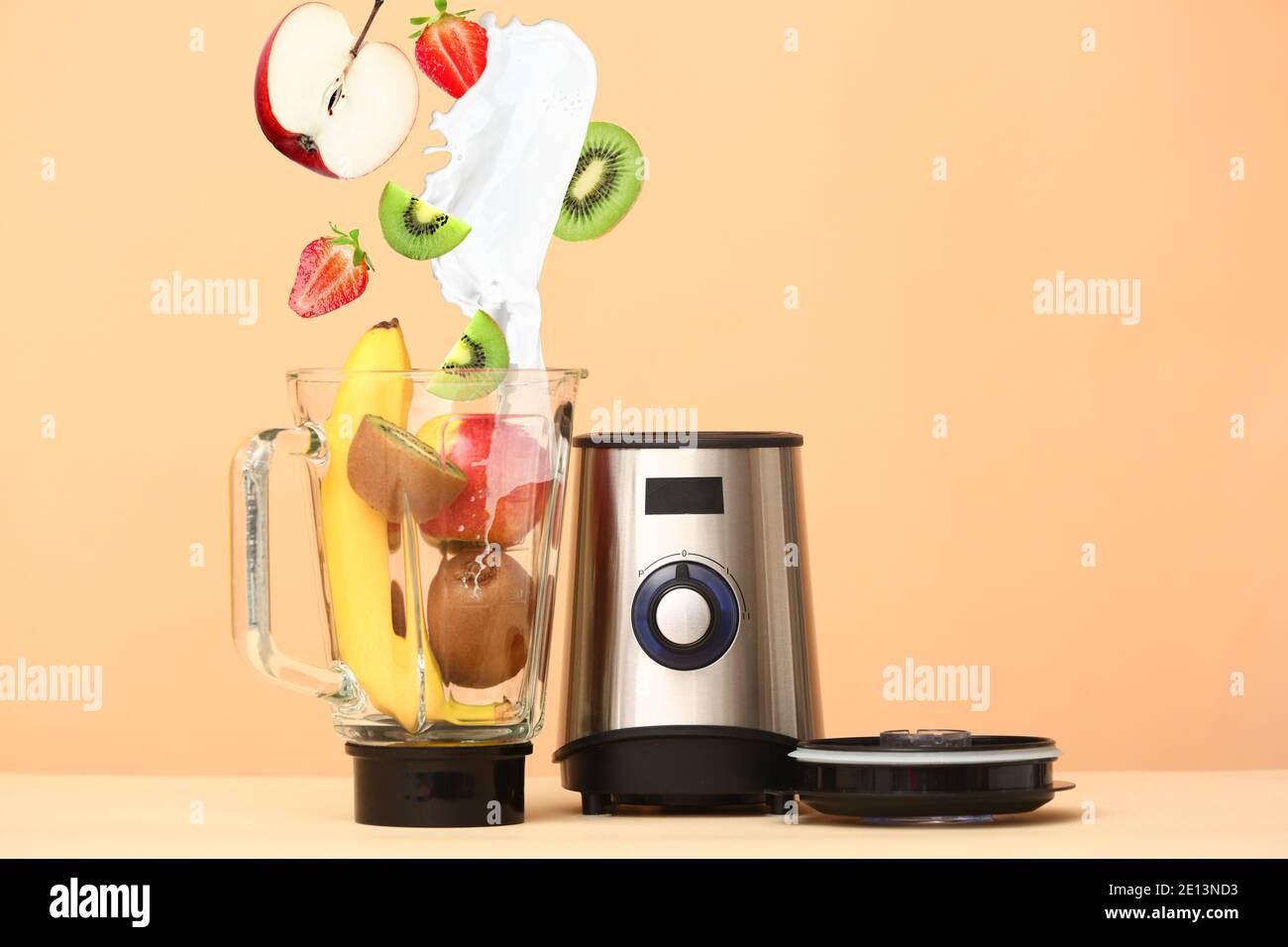 Blender with falling ingredients for healthy smoothie on color ...