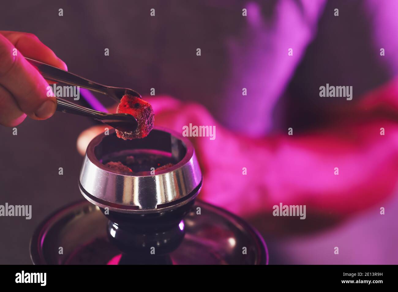 Man putting coal cubes on tobacco bowl, closeup Stock Photo - Alamy