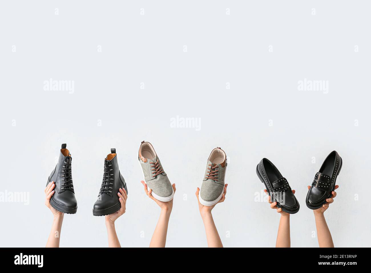 Hands with stylish shoes on white background Stock Photo - Alamy