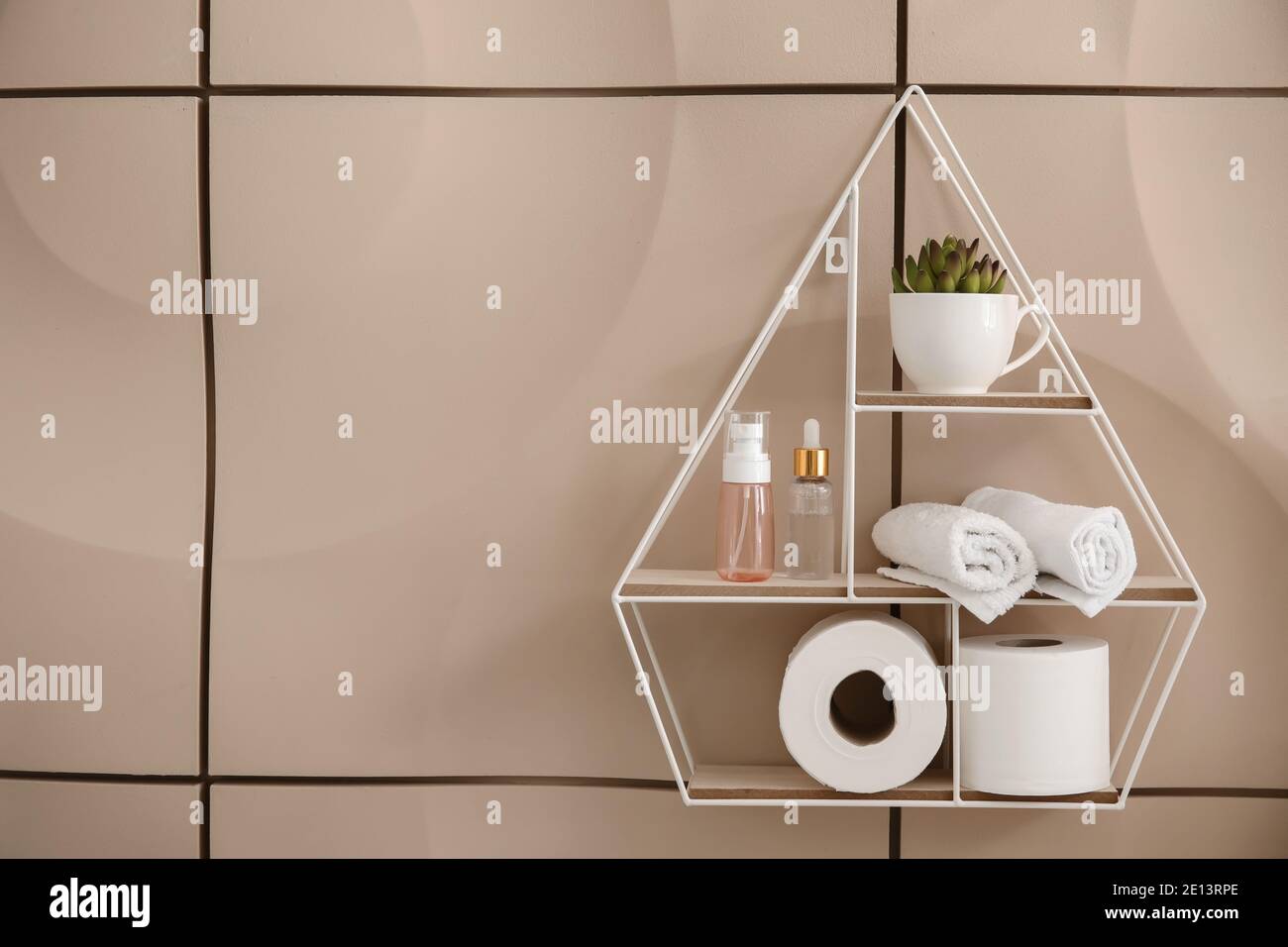 Modern shelf with body care cosmetics and accessories on color wall in ...