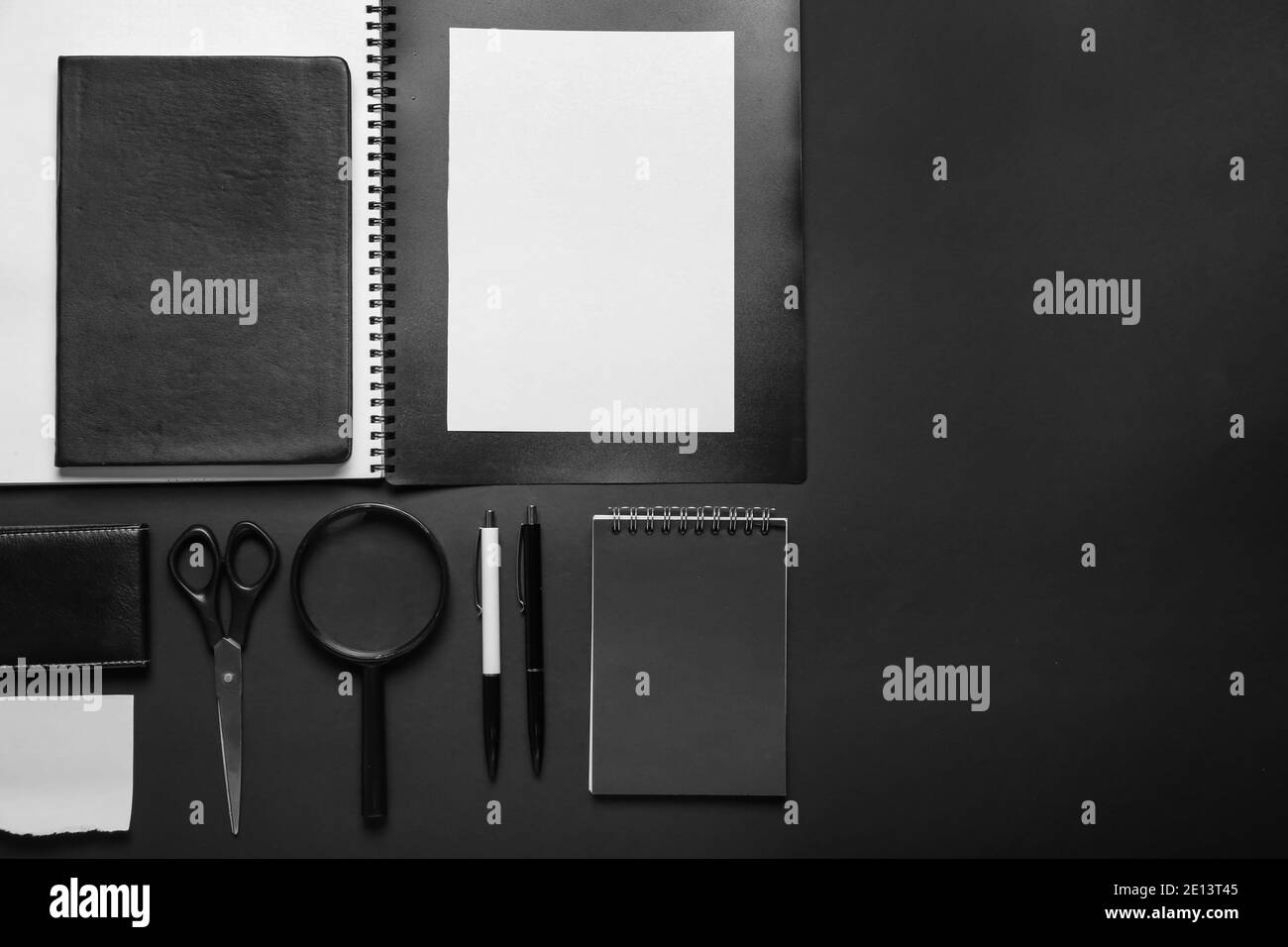 Composition with blank paper sheet and stationary on dark background ...