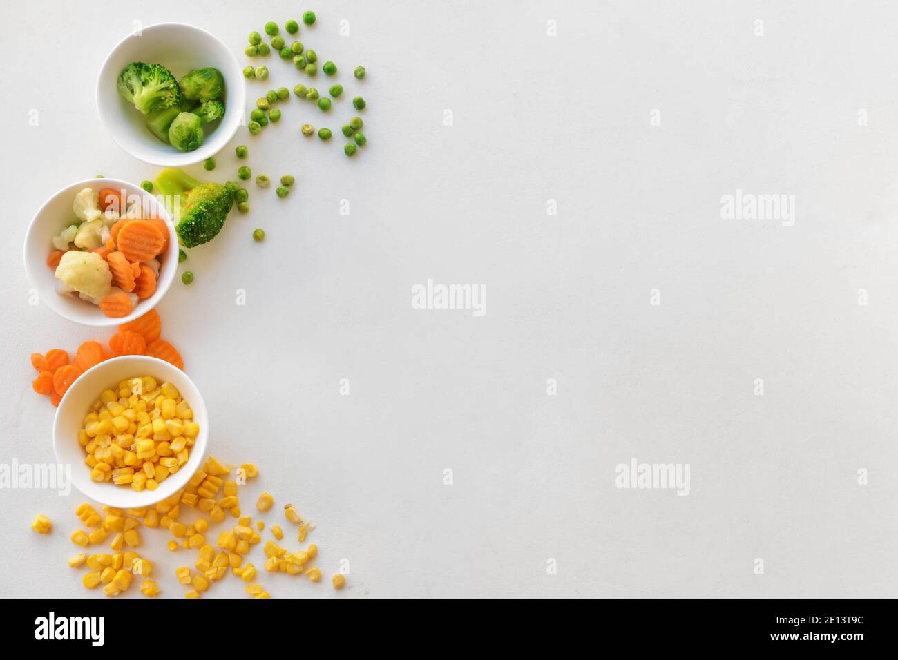 Frozen vegetables in bowls on white background Stock Photo - Alamy
