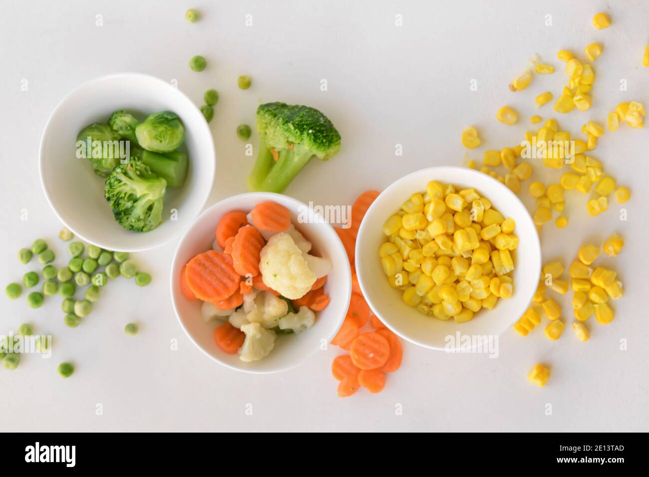 Frozen vegetables in bowls on white background Stock Photo - Alamy