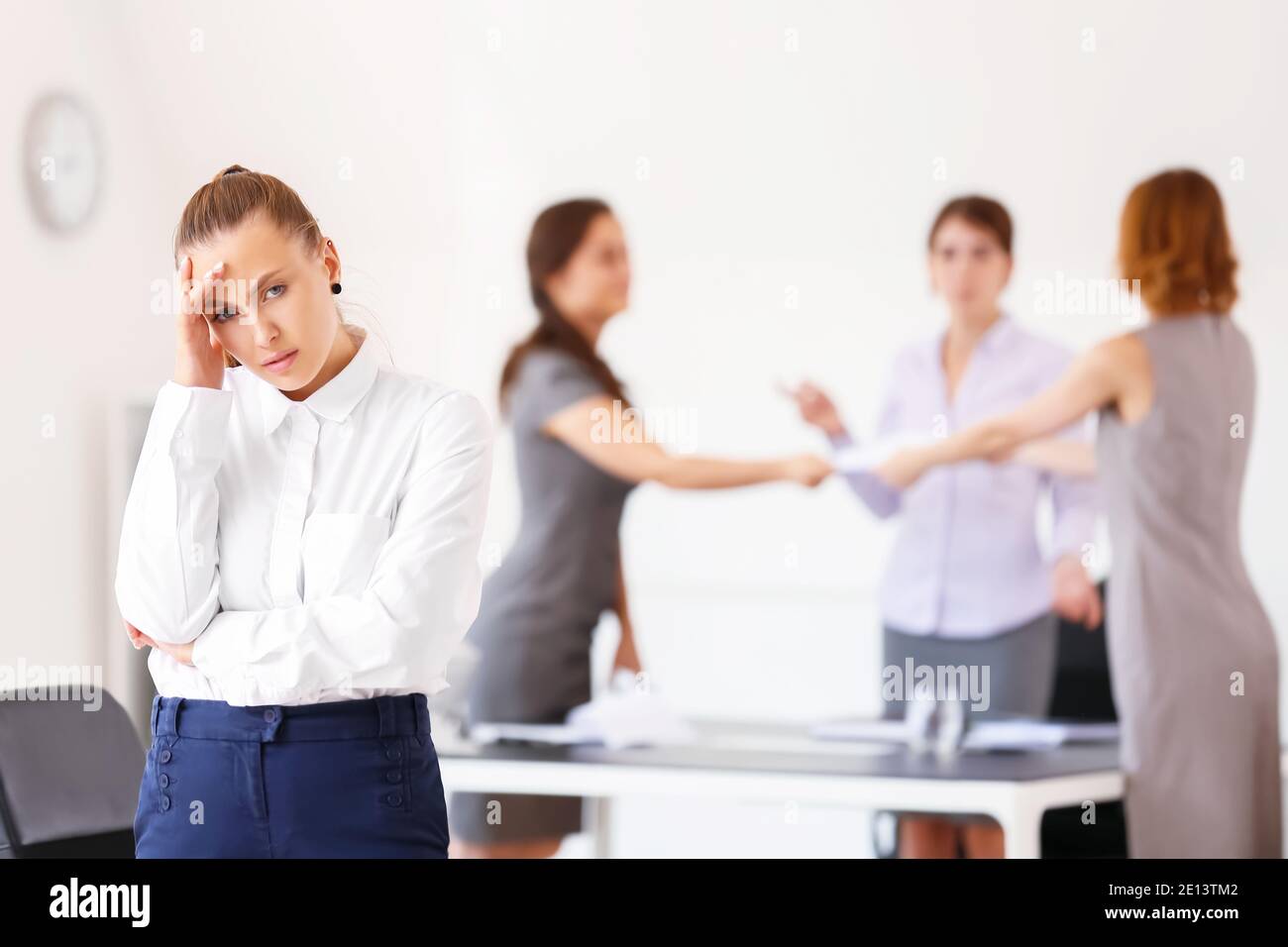 Stressed woman with headache and noisy people in office Stock Photo - Alamy