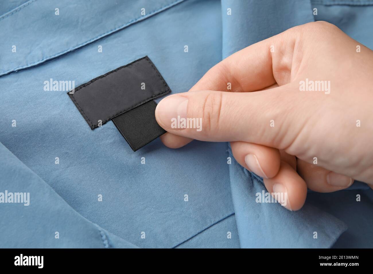 Hand and blank label on clothes Stock Photo - Alamy