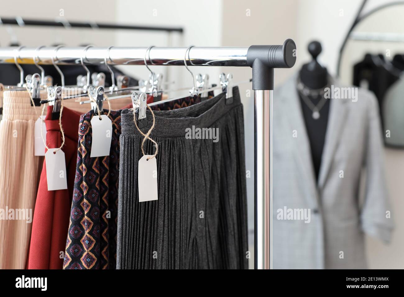 Clothes on hangers with blank paper labels Stock Photo - Alamy