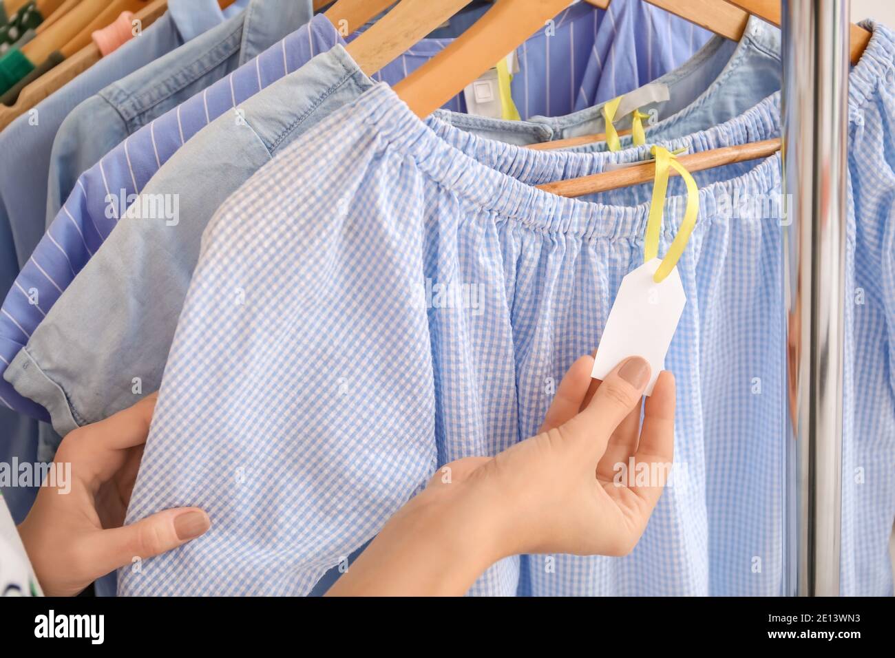 Female hands and blank paper label on clothes Stock Photo - Alamy