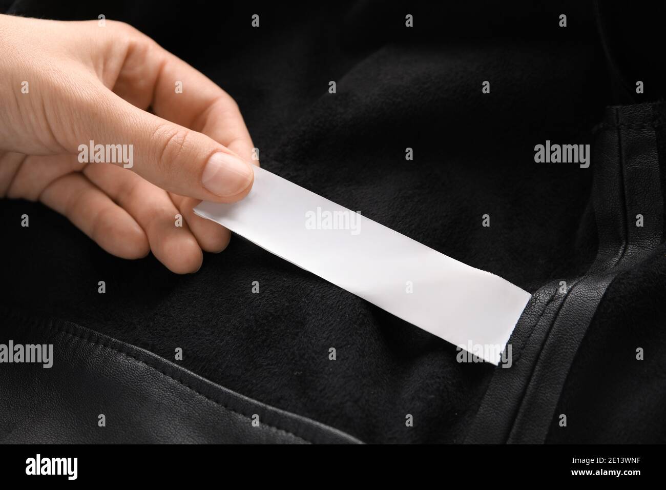 Hand and blank label on clothes Stock Photo - Alamy