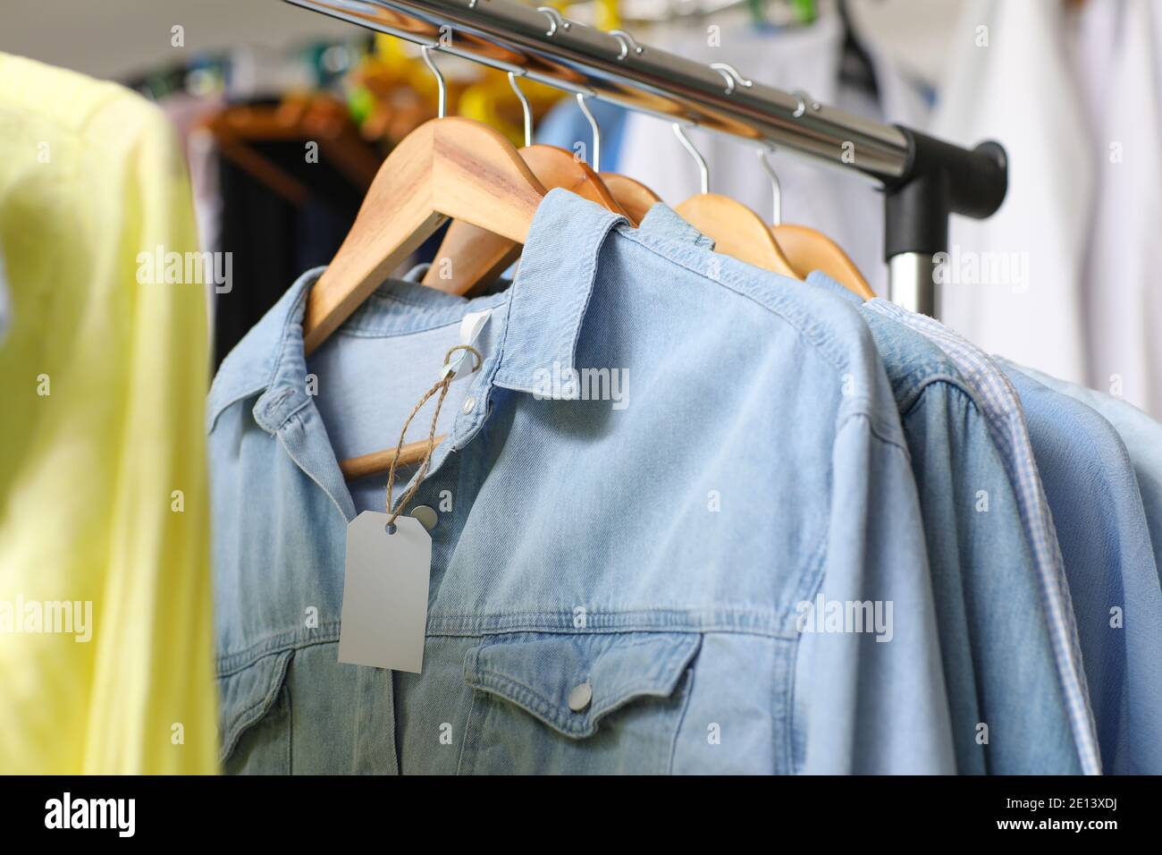 Clothes on hangers with blank paper labels Stock Photo - Alamy