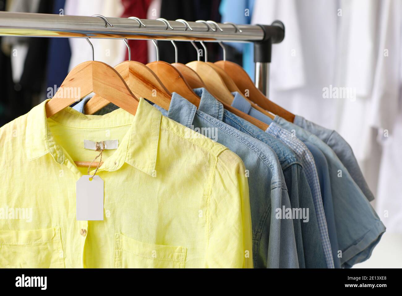 Clothes on hangers with blank paper labels Stock Photo - Alamy