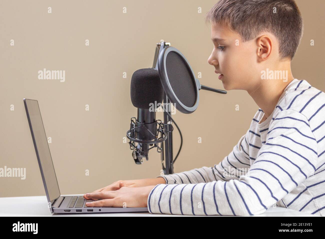 Kid with laptop computer talking into microphone. Techology, online ...