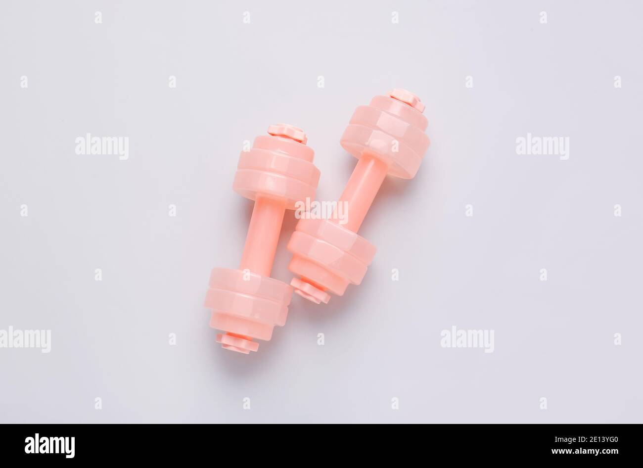 Stylish dumbbells on light background Stock Photo - Alamy