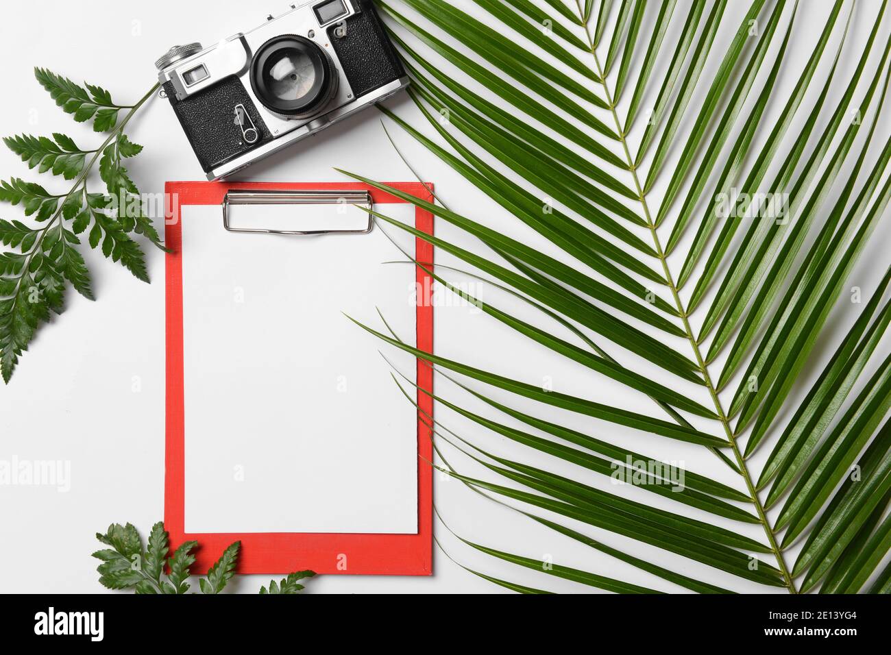 Clipboard with blank paper sheet and photo camera on white background ...