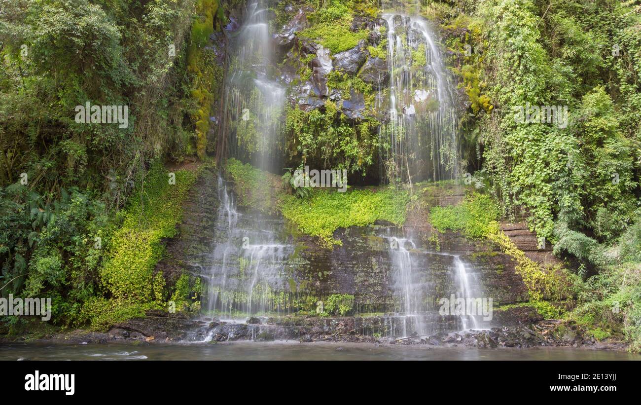 Waterfall running down a cliff from a spring high on the valley side ...