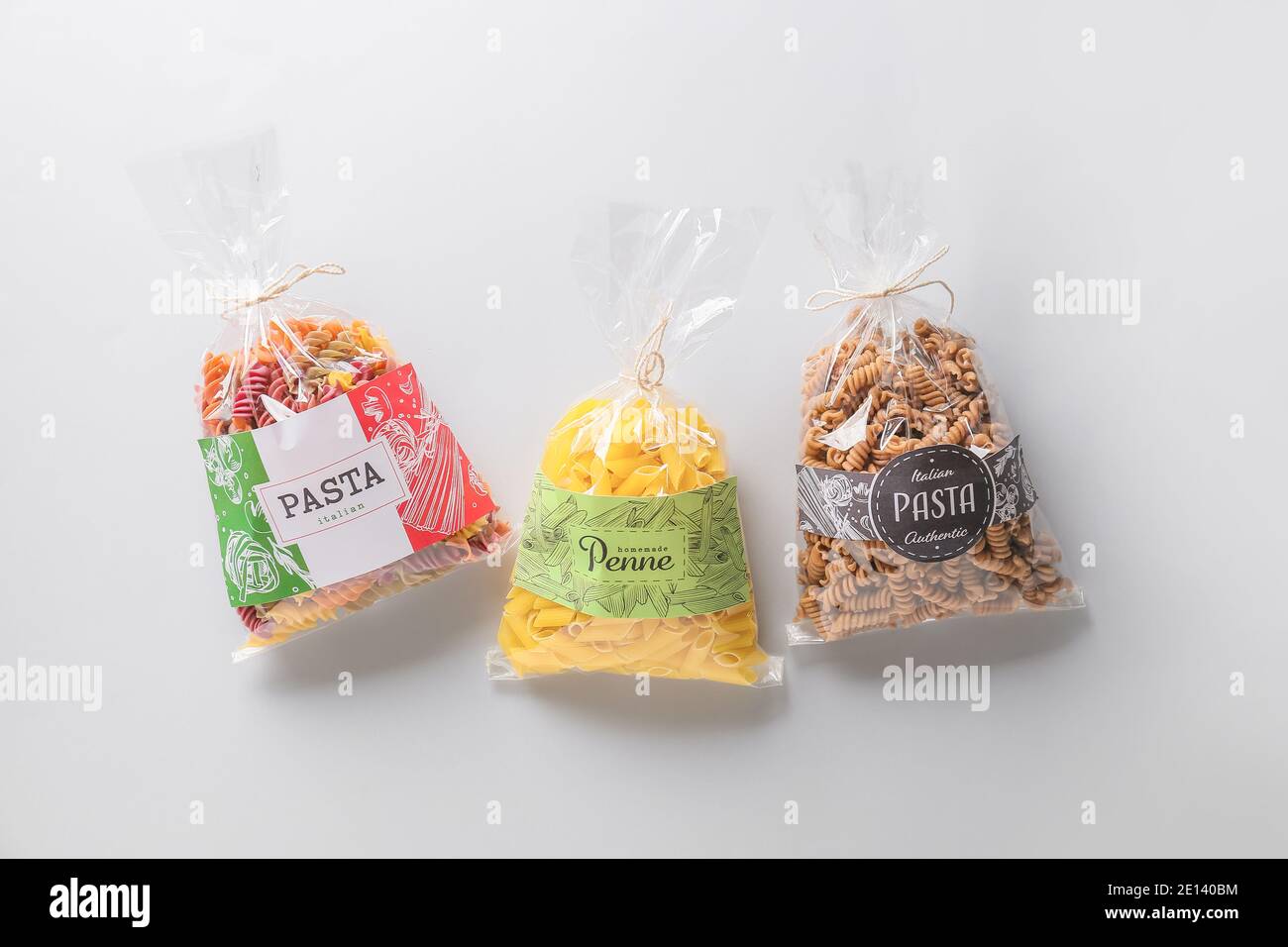 Bags with uncooked pasta on white background Stock Photo - Alamy