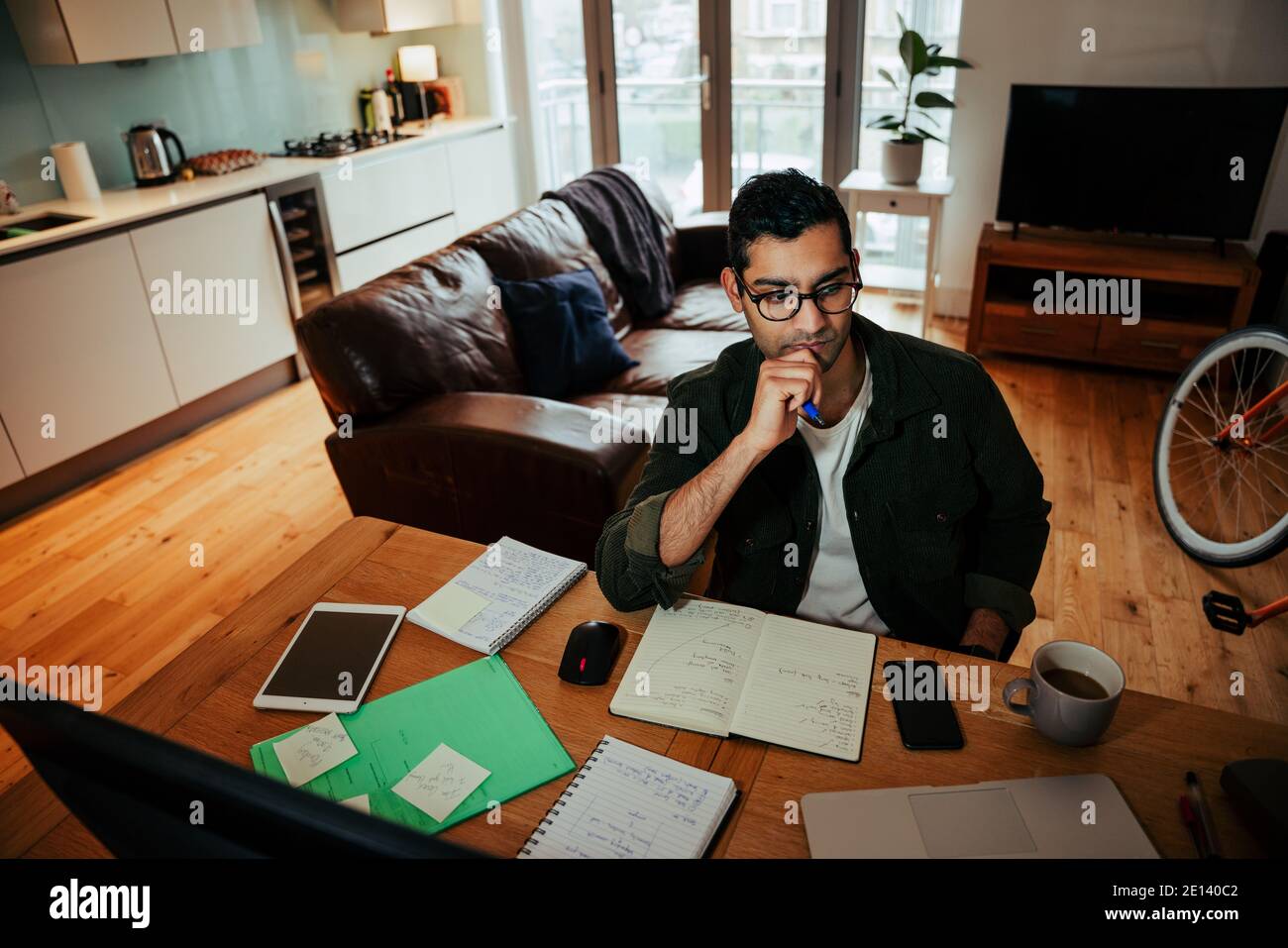 Mixed race businessman concerntrating while reading off desktop ...