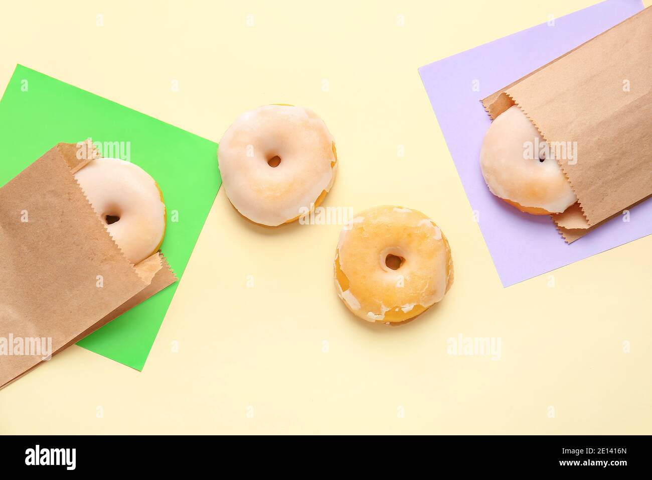 Tasty donuts in paper bags on color background Stock Photo - Alamy