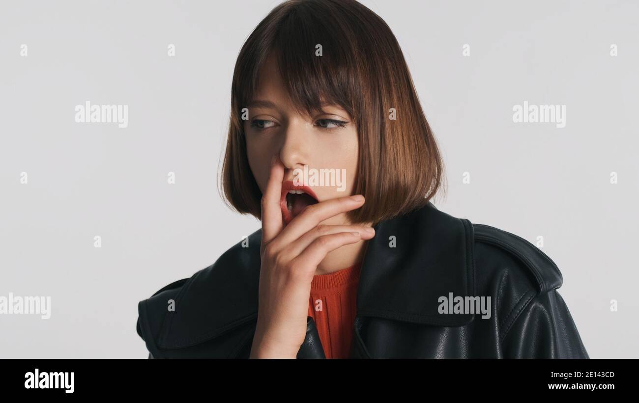 Bored brunette girl with bob hair yawning on camera isolated on white ...