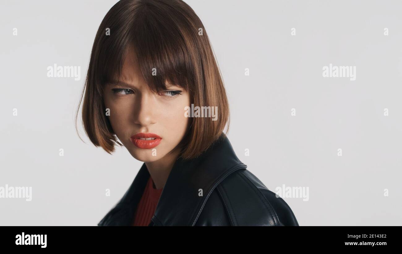 Angry brunette girl with bob hair and red lips looking with moody ...