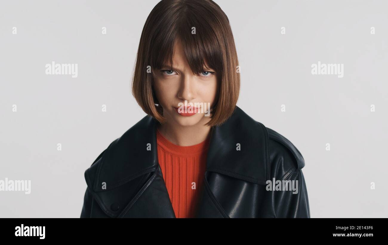 Serious brunette girl with bob hair looking from under the forehead ...