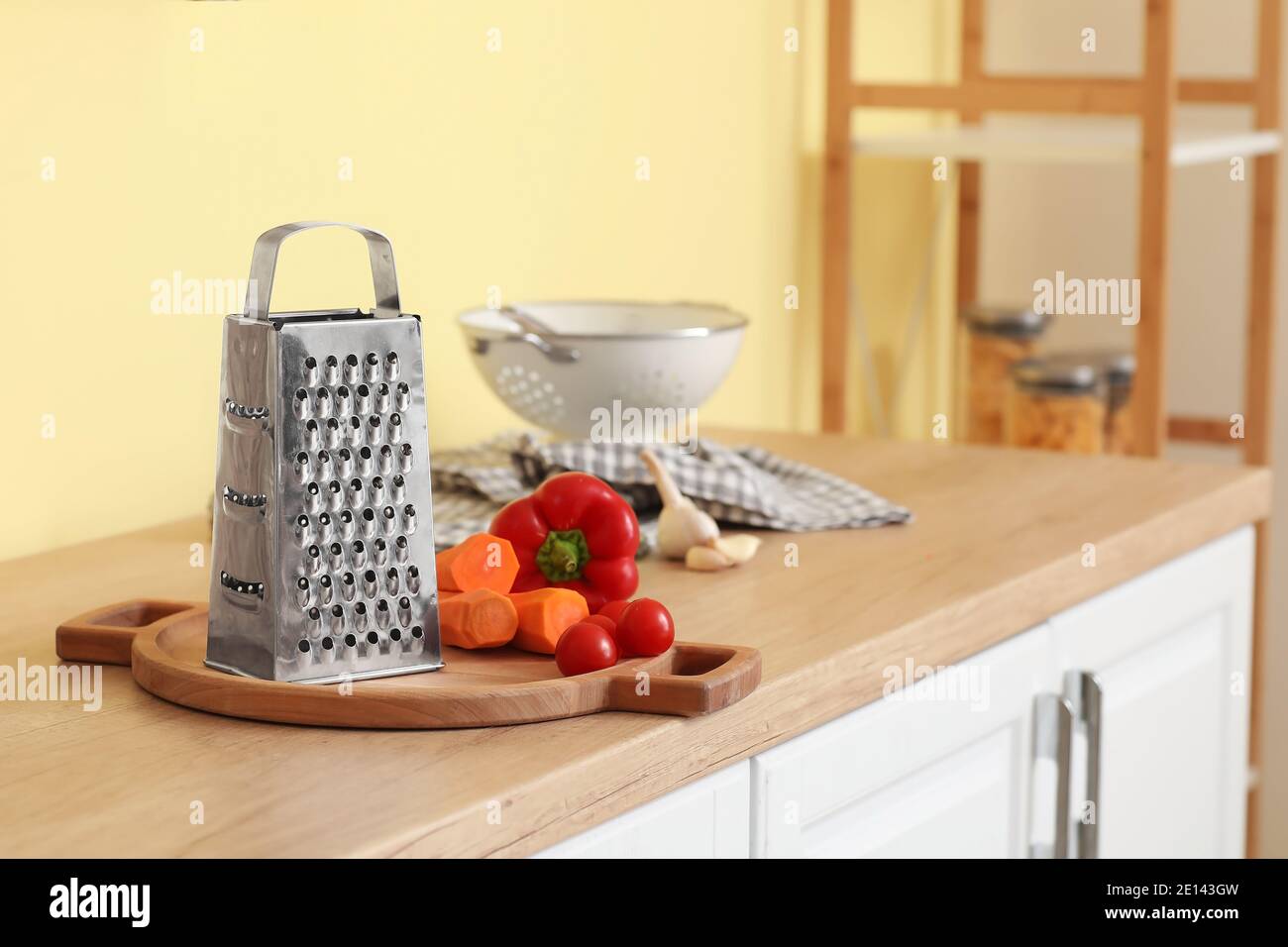 Grater, cutting board and vegetables on kitchen counter Stock Photo - Alamy