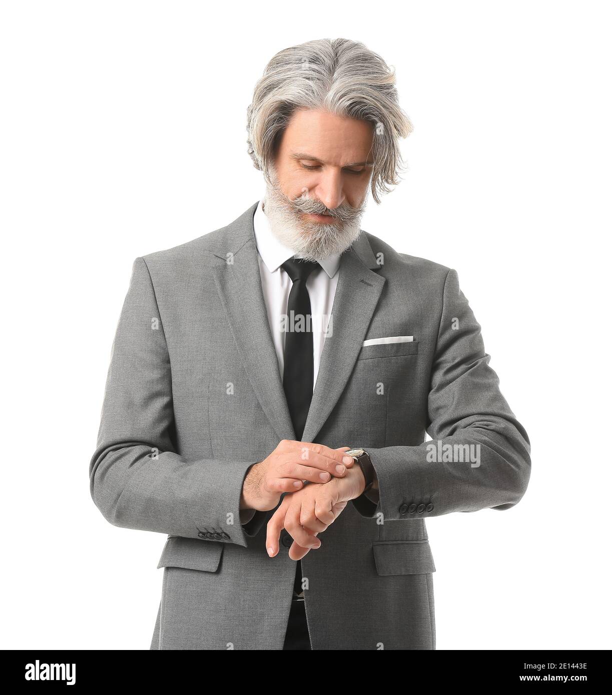 Portrait of senior businessman looking at his watch on white background ...