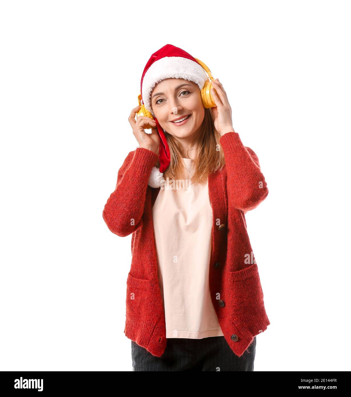 Mature woman listening to Christmas music on white background Stock ...