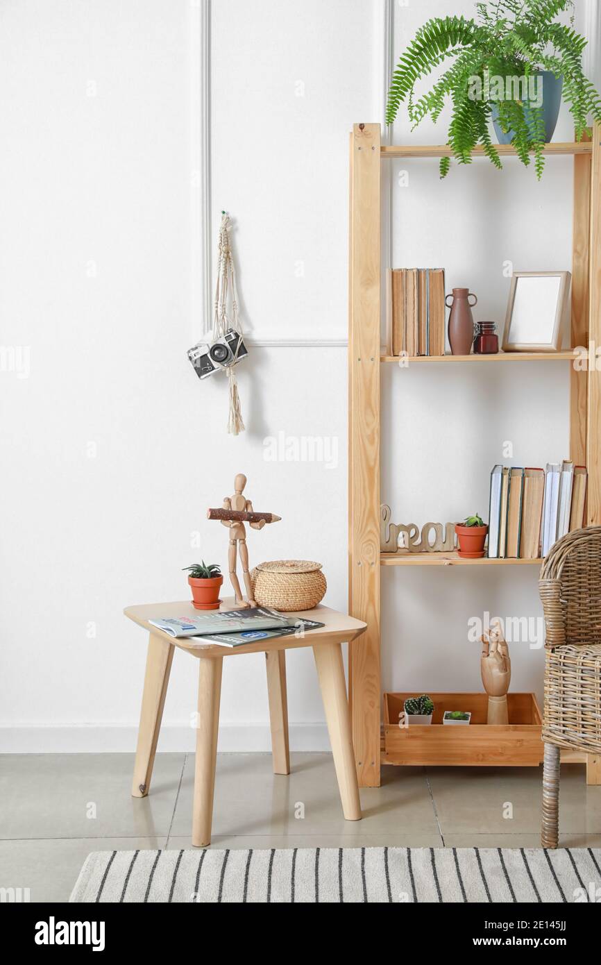 Interior of modern room with shelf unit and table Stock Photo - Alamy