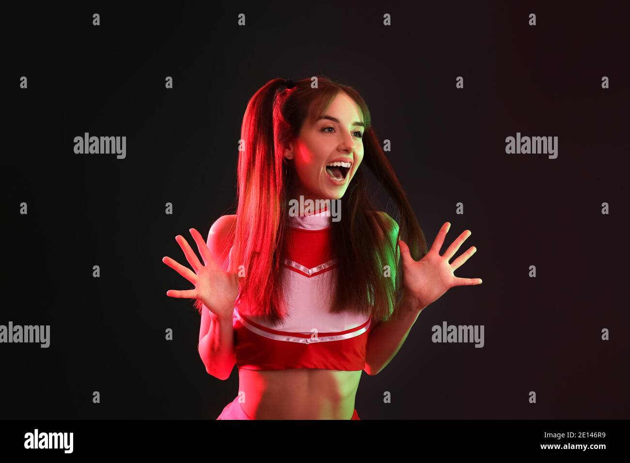 Emotional cheerleader on dark background Stock Photo - Alamy