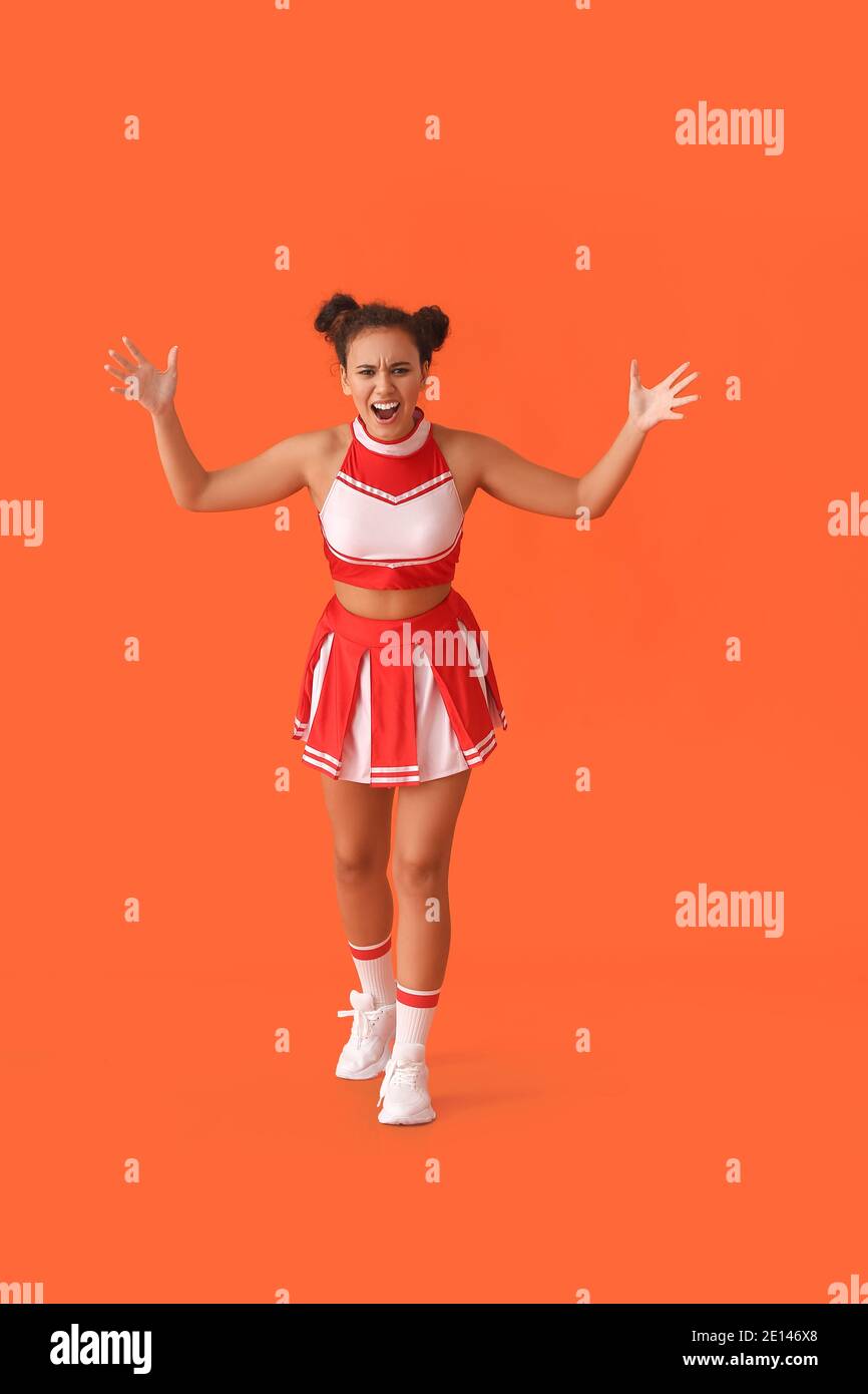 Emotional cheerleader on color background Stock Photo - Alamy