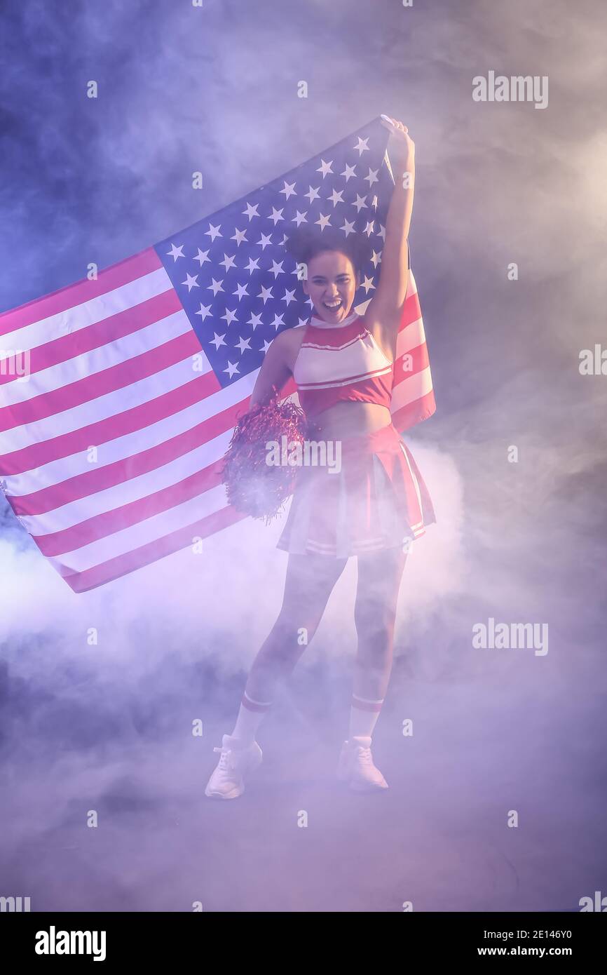 Beautiful young cheerleader with USA flag in smoke Stock Photo - Alamy